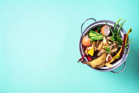 지속 가능하고 폐기물이 없는 생활 퇴비 냄비를 재활용 하는 야채 폐기물 상단 보기 공간을 복사합니다 도마에 껍질을 벗긴 야채 파란색 배경에 흰색 퇴비 빈 주방 폐기물을