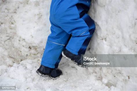 겨울 바지 산책에 작은 아이는 이글루를 구축 할 것입니다 어린 소년이 지붕을 올라간다 얼음 벽에 덮개에 빙하 그의 어머니는 등반가로서의 경력을 위해 그를 훈련시다 그는