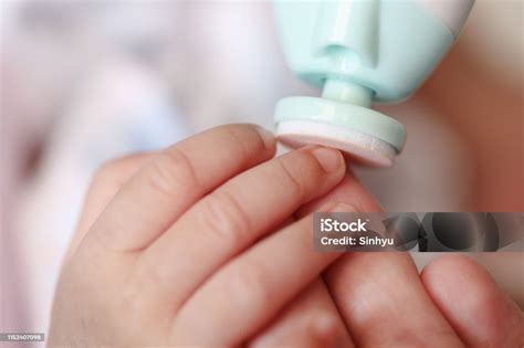 네일 파일로 손톱을 잘라 어머니는 자동 아기 손톱 파일 기계를 사용 하 여 아기 손톱을 작성 합니다 가위에 대한 스톡 사진 및 기타 이미지 Istock