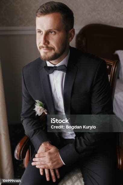 검은 양복에 나비 넥타이 창 빛에의 자에 앉아 세련 된 신랑 남자의 자신감과 행복 초상화입니다 아침에 준비 하는 신랑 검은색에 대한 스톡 사진 및 기타 이미지 Istock