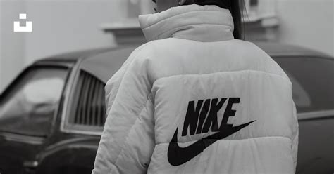 흰색과 검은색 아디다스 까마귀를 입은 여자가 검은색 차 근처에 서 있습니다 사진 Unsplash의 무료 여자 이미지