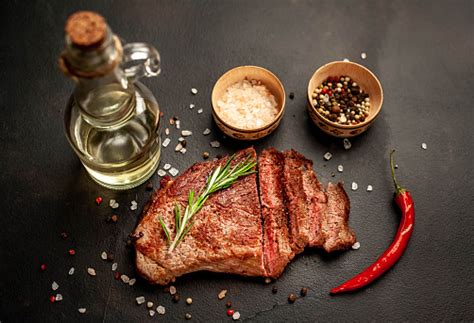 콘크리트 배경에 재료와 함께 뉴욕 블랙 앵거스 쇠고기 품종의 바로 먹을 스테이크 어두운 돌 배경에 저녁 식사를 위한 준비 식사