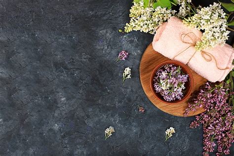 어두운 배경에 나무 그릇에 라일락 꽃 향기로운 물과 스파와 웰빙 구성 아로마 테라피와 피부와 바디 케어 플랫 레이 최고 전망 라이프 스타일 개념과 현대 여성 계절에 대한
