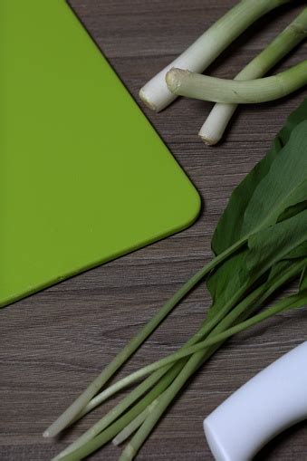 테이블 위에 신선한 채소 들이 깔끔하게 배치 되었습니다 향기로운 양파와 야생 마늘 부엌 칼과 커팅 보드 옆에 있습니다 건강 한 샐러드를 위한 재료 0명에 대한 스톡 사진 및