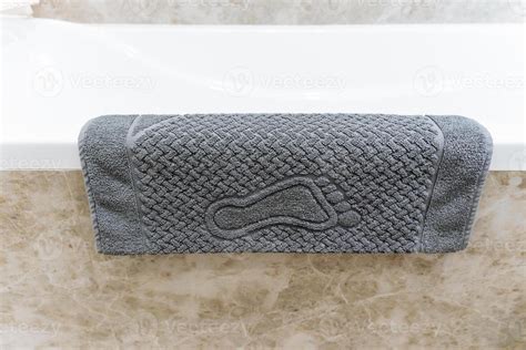 On The Edge Of The Bathtub There Lies A Bath Mat Featuring An Imprint