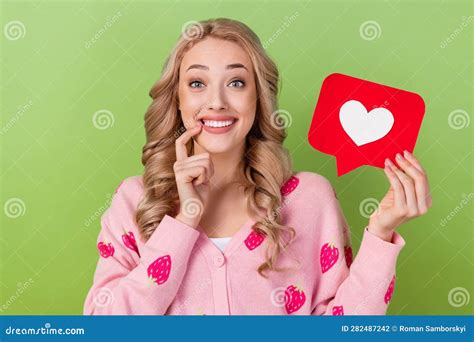Photo Of Young Lady Bite Her Finger Touch Chin Smile Excited Hold Heart Symbol Share Like Repost