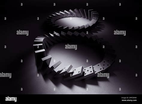 Domino Loop Falling In Moody Lighting Creates Intricate Shadows And