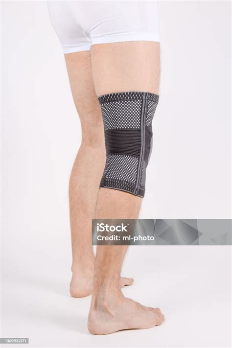흰색 배경에 고립 된 다리에 무릎 지원 보조기 탄성 정형 외과 성 성 무릎 고정 부상 과 통증에 대한 해부학 중괄호 보호 무릎 관절 붕대 소매 외상 재활