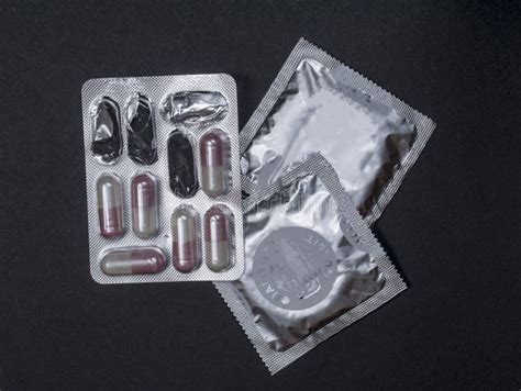 Birth Pills And Condoms On Black Background Contraception Concept