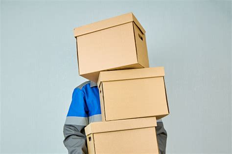 로더 나 택배는 작업복을 입고 파란색 벽을 따라 골판지 상자를 운반합니다 귀여운에 대한 스톡 사진 및 기타 이미지 귀여운 긍정적인 감정 표현 남성 Istock