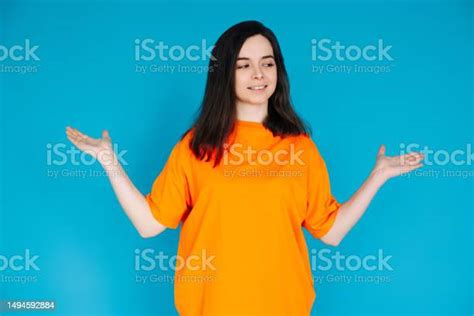 손바닥에 빈 복사 공간을 들고 웃고 있는 젊은 여성 밝은 파란색 배경에 고립된 매력적인 여성 모델 인물 사진 20 24세에 대한