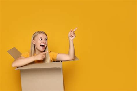 Una Chica Joven Se Sienta En Una Caja De Cartón Foto Premium