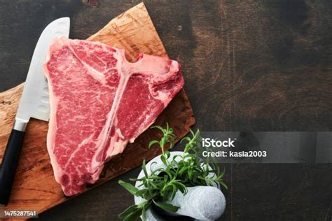 두꺼운 생 티본 스테이크 드라이 에이징 생 티본 또는 포터하우스 쇠고기 고기 어두운 배경에 허브와 소금으로 멧돼지를 자르는 스테이크 평면도 및 복사 공간 0명에 대한 스톡