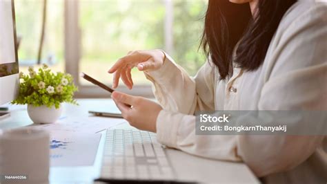 스마트폰을 사용하는 아시아 사업가가 사무실 책상에 앉아 있는 측면 이미지 25 29세에 대한 스톡 사진 및 기타 이미지 25 29세 경영자 금융 Istock