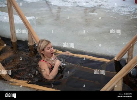 Woman Bathes Into Cold Water Of Ice Hole On Epiphany Day In Neva River