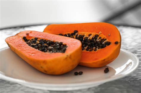 흰색 접시에 씨앗과 반 잘라 잘 익은 파파야 흰색 배경달콤한 파파야 조각 반으로 자른 파파야 건강한 이국적인 과일 채식 음식 0