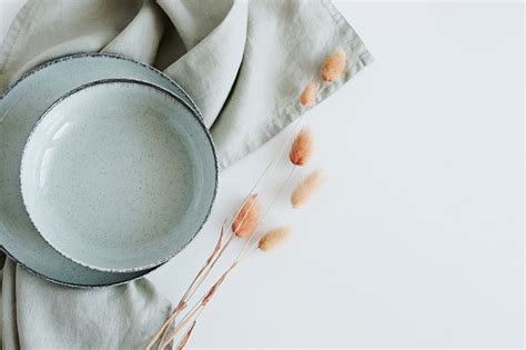 플레이트 모형 린넨 냅킨 마른 잔디 탑 뷰 빈 현대 최소 테이블 장소 설정 중립 녹색 색상 텍스트 또는 메뉴를 위한 공간 비즈니스 식품 브랜드 템플릿입니다 스칸디나비아