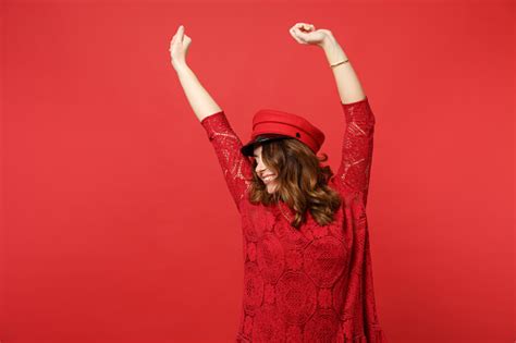 귀여운 젊은 여자 레이스 드레스와 모자를 옆으로 찾고 웃는의 초상화 스튜디오에서 밝은 빨간색 벽 배경에 고립 된 상승 손 사람들은 진심으로 감정 라이프 스타일 개념입니다