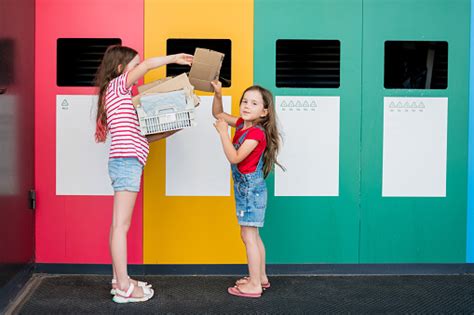 재활용 센터에서 골판지 쓰레기를 버리는 소녀들 재활용 쓰레기통에 종이를 넣는 아이들 지속 가능한 라이프스타일 개념 전국 재활용 주간 2명에 대한 스톡 사진 및 기타 이미지