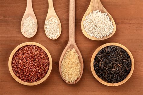 다양 한 형태의 쌀 어두운 소박한 나무와 배경에 복사 공간 위에서 총 모음 레드 와일드 블랙 긴 곡물 파에 리아 리조또 텍스트에 대 한 장소를 가진 재 스민 쌀 0명에 대한