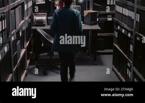 African American Woman Examining Evidence Map To Find Suspect Using Detective Board On Office