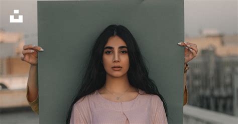 분홍색과 흰색 물방울 무늬 드레스를 입은 여자는 낮에 회색 콘크리트 벽 옆에 서 있다 사진 Unsplash의 무료 유행 이미지