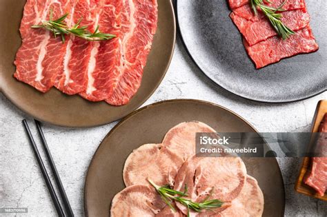 회색 돌 배너 배경에 격리된 일본과 한국 음식 평면도 다양한 그릴을 위해 접시에 신선한 생 쇠고기 스테이크 고추와 허브 0명에