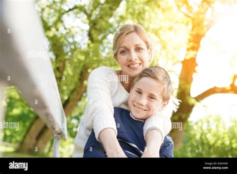 Portrait Of Mother And Son Sitting On Bench In Park Stock Photo Alamy