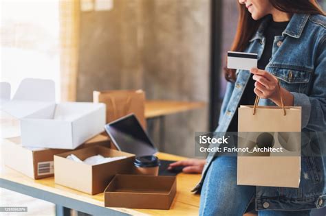 테이블에 우편 소포 상자와 온라인 쇼핑을 위해 신용 카드와 태블릿 Pc를 들고 사용하는 여성 가방에 대한 스톡 사진 및 기타 이미지 Istock