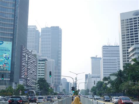 낮 동안 고층 건물 근처 주차장에 주차 된 자동차 사진 Unsplash의 무료 길 이미지