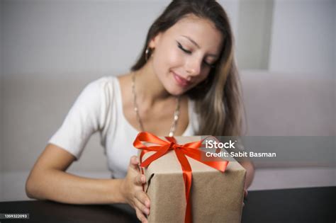 크래프트 페이퍼에 싸여 빨간 리본으로 선물 상자를 들고 미소 짓는 여자 실내 사진 20 24세에 대한 스톡 사진 및 기타 이미지 20 24세 갈색 용지 감정 Istock