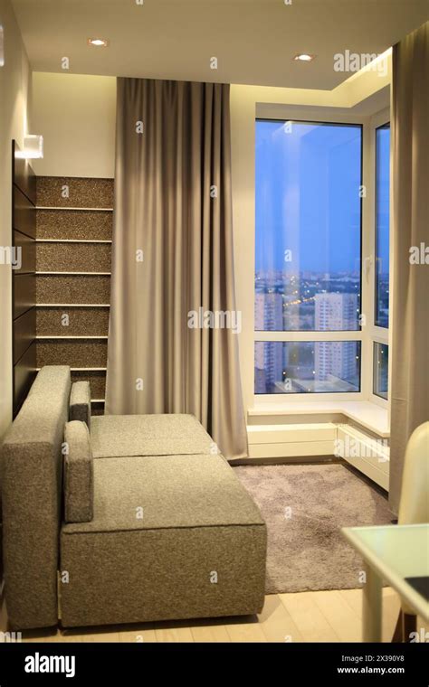 Sofa In Front Of An Angular Window With Curtains In The Room Stock Photo Alamy