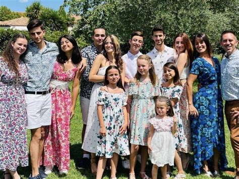 A Group Of People Standing Next To Each Other On A Lush Green Field