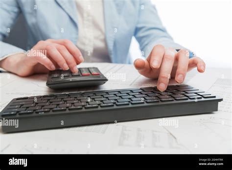 Business Woman Using Calculator And Computer Keyboard At Office Stock