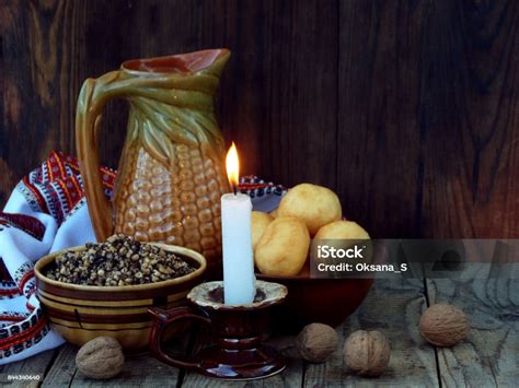 양 귀 비와 견과류 Pampushki Uzvar 설탕에 절인 과일의 말린 과일 나무 배경에서 촛불을 굽기 크리스마스 기호 Kutya 밀 죽의 구성 크리스마스 이브에