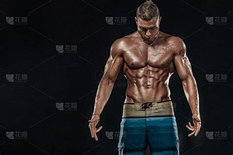 现场进行健美比赛。男子运动员体格和运动员。黑色背景和灯光。