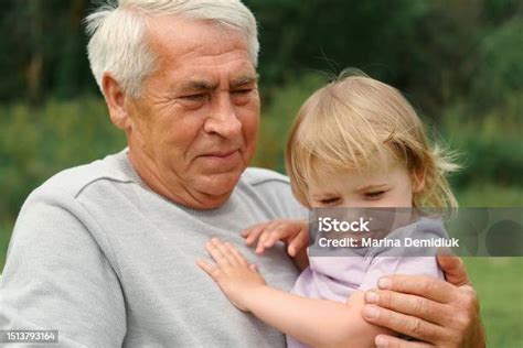 할아버지와 손자 아기는 공원에서 산책하는 동안 즐거운 시간을 보냅니다 행복한 가족 여름날에 2살짜리 어린 소녀를 껴안고 있는 늙은 남자 할아버지 손녀와 함께 시간을 보내는