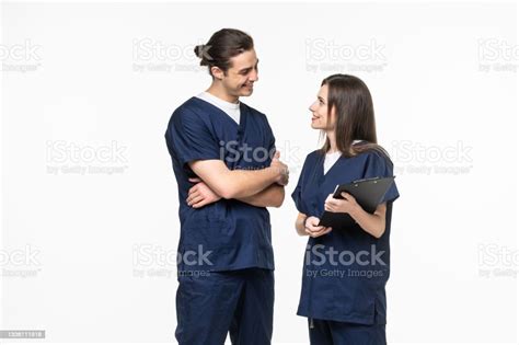 흰색 실험실 코트를 입은 두 명의 똑똑한 남성과 여성 전체 길이 의사가 흰색 배경의 클립보드에 대한 의학 처방에 대해 논의합니다