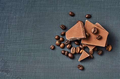 어두운 긁힌 콘크리트 테이블에 흩어져 튀긴 커피 콩과 쓴 또는 밀크 초콜릿의 깨진 조각의 힙 텍스트의 공백입니다 맨 위 보기 갈색에 대한 스톡 사진 및 기타 이미지 Istock