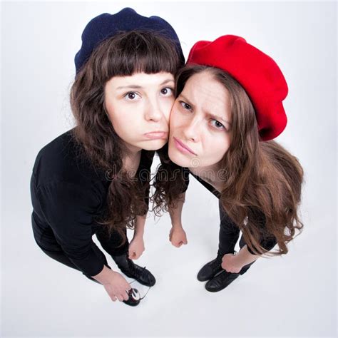 Δύο χαριτωμένα κορίτσια που έχουν τη διασκέδαση και που κάνουν τα αστεία πρόσωπα Στοκ Εικόνες