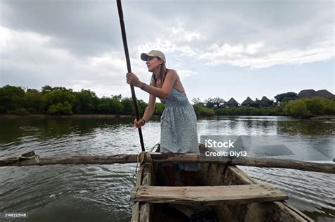 한 관광 소녀가 아프리카의 콩고 강에서 낡은 배를 젓고 있다 나무 카누를 젓는 여자의 모습 카누 소녀 노를 젓는 목조 보트 30 34세에 대한 스톡 사진 및 기타 이미지