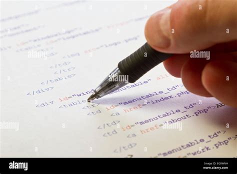 A Programmer Man Pointing With His Pen At Html Code For A Web Page