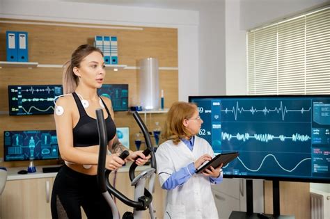 Premium Photo Fit Female Testing The Stepper With Electrodes On It And The Doctor Watching The