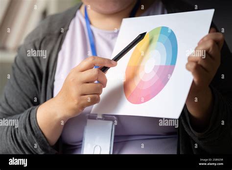 Graphic Designer Analyzing A Color Wheel For Creative Design Projects