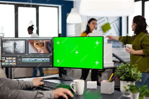 グリーンスクリーン、クロマキー、モックアップ分離ディスプレイを備えたpcのクリエイティブエージェンシーで働くポストプロダクションソフトウェアを