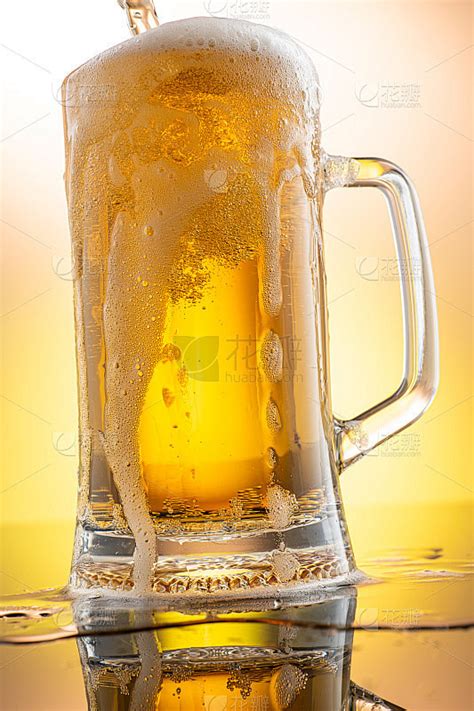 将啤酒从黄色背景的瓶子中倒入啤酒杯中