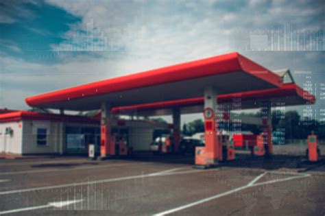 기술적 배경에 연료 디스펜서가있는 주유소 휘발유 및 연료 가격 상승 그래프 연료 가격 상승과 글로벌 위기 유가에 대한 스톡 사진