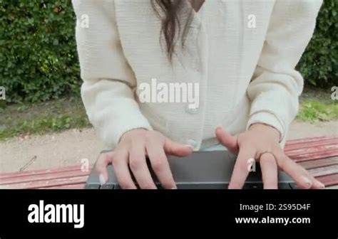 Tilt Up Close Up Shot Of Young Woman Typing On Her Laptop With Focused Expression While Working