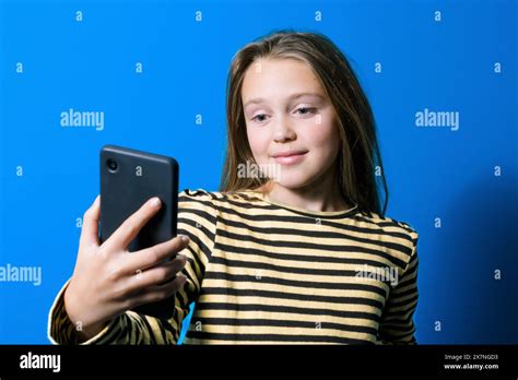 A Teenage Girl Takes A Selfie On Her Phone Close Up Portrait Blue
