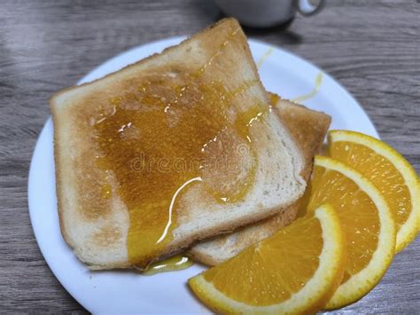 Fried White Bread Doused With Honey On A White Plate Stock Image